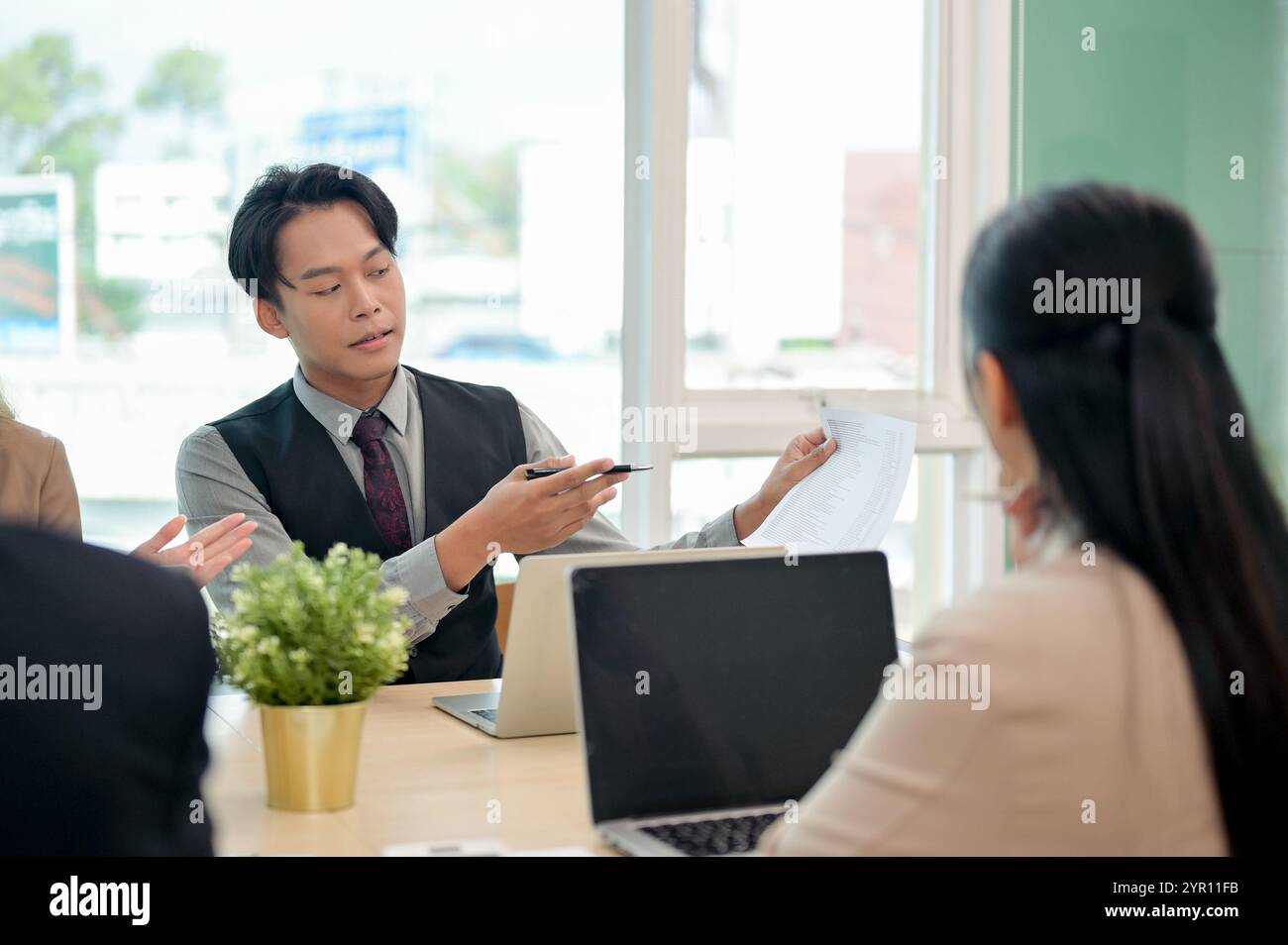 A professional, smart Asian businessman in a formal suit confidently ...