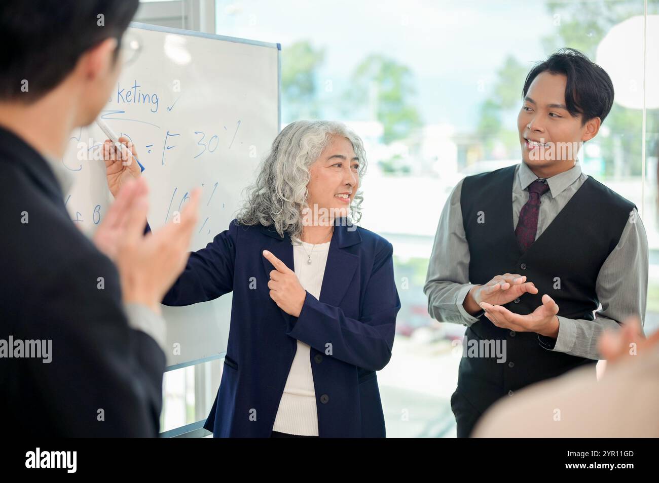 A productive senior Asian female CEO or manager leading the meeting ...
