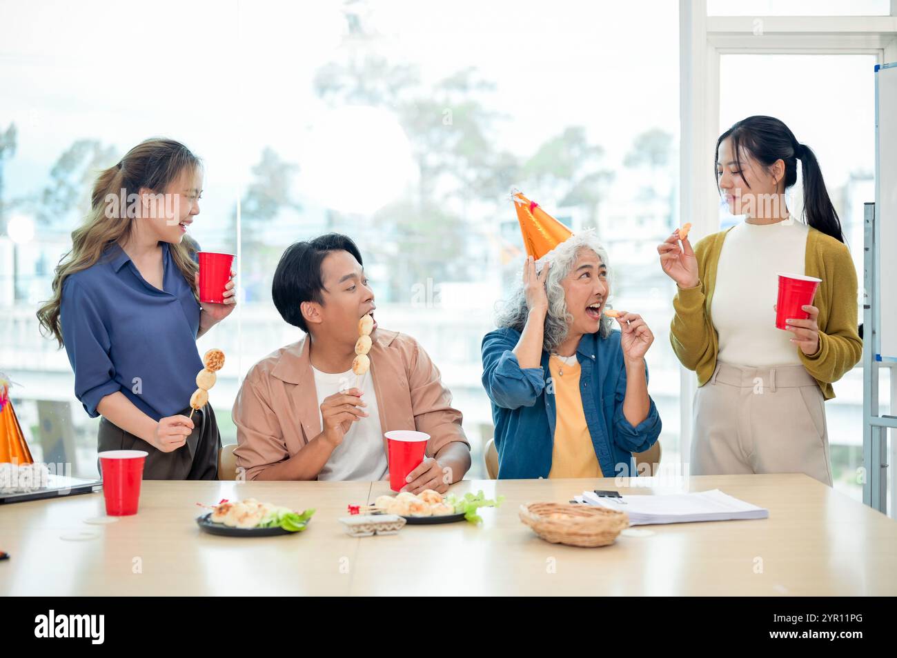 A group of joyful Asian diverse startup businesspeople celebrate in the ...