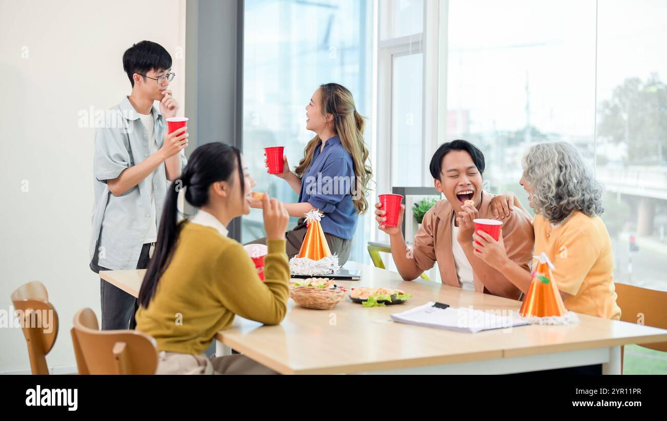 Smiling, cheerful diverse Asian employees enjoy drinks and ...