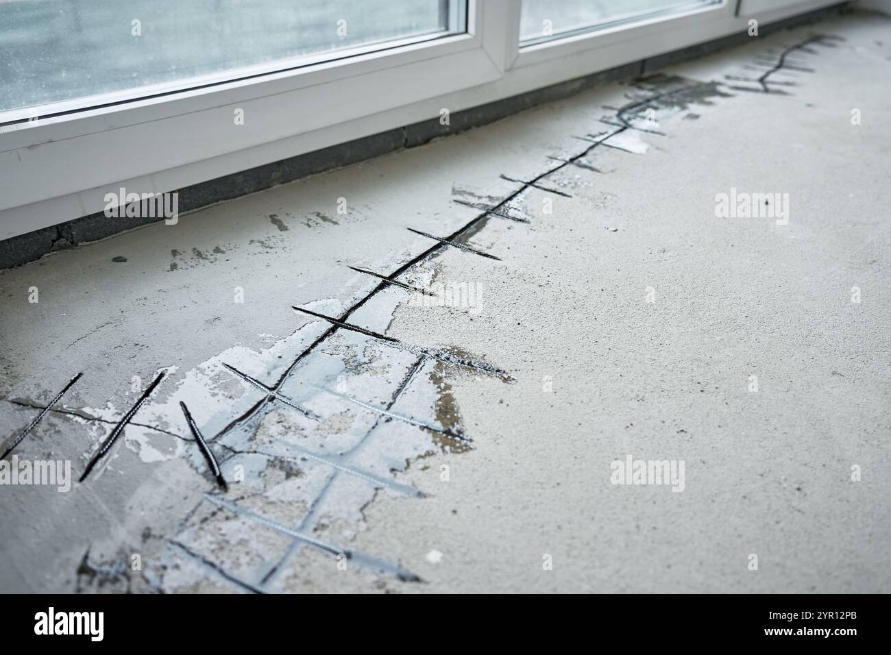 Repairing cracks in concrete floor near window using sealant ...