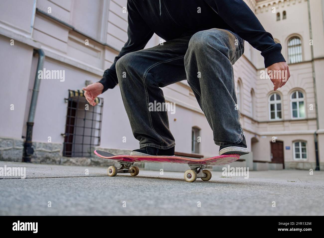 Skateboarder doing trick at urban street. Close up of skater wearing ...