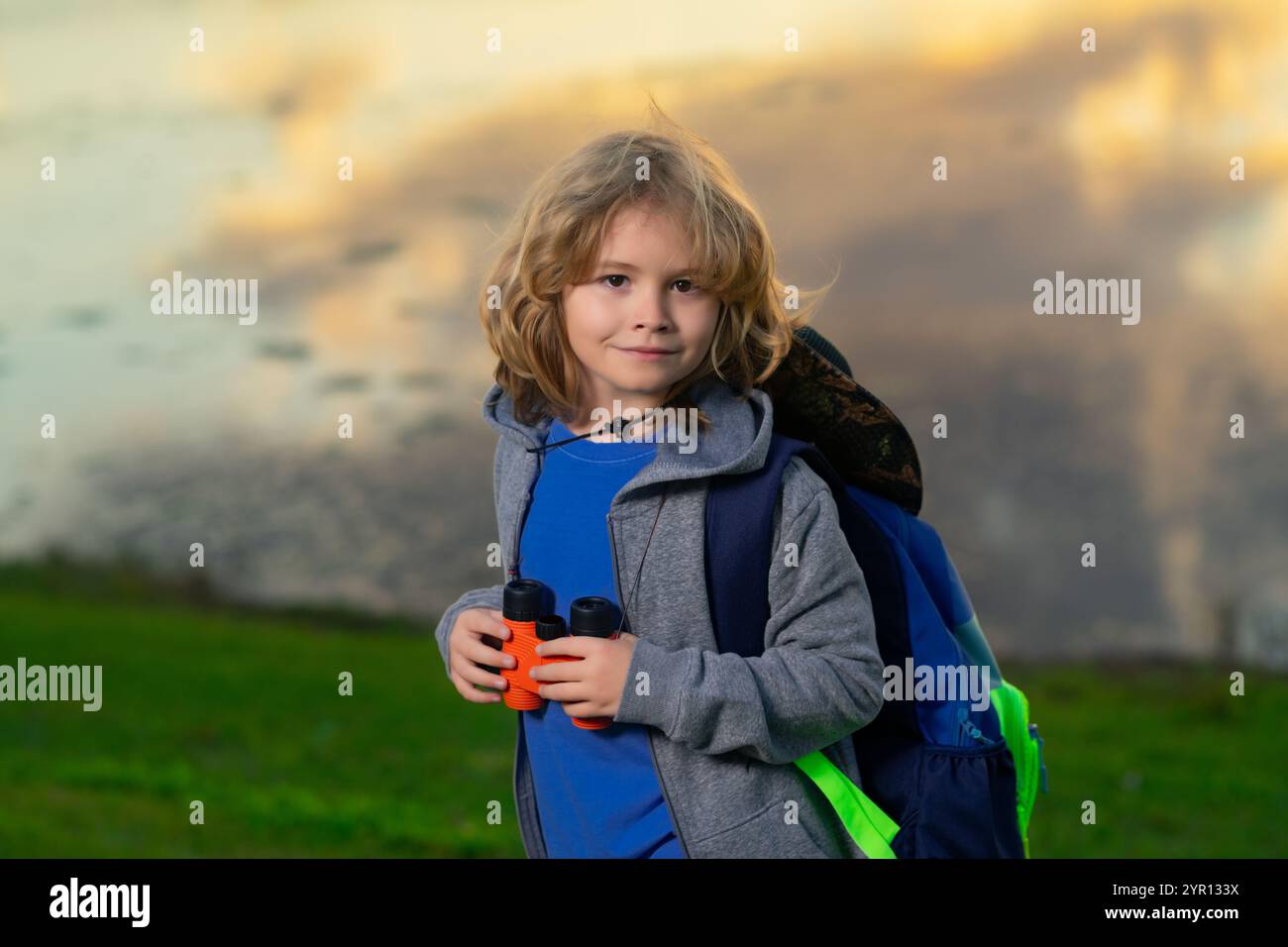 Child discovery concept. Cute blond kid with binoculars wearing ...