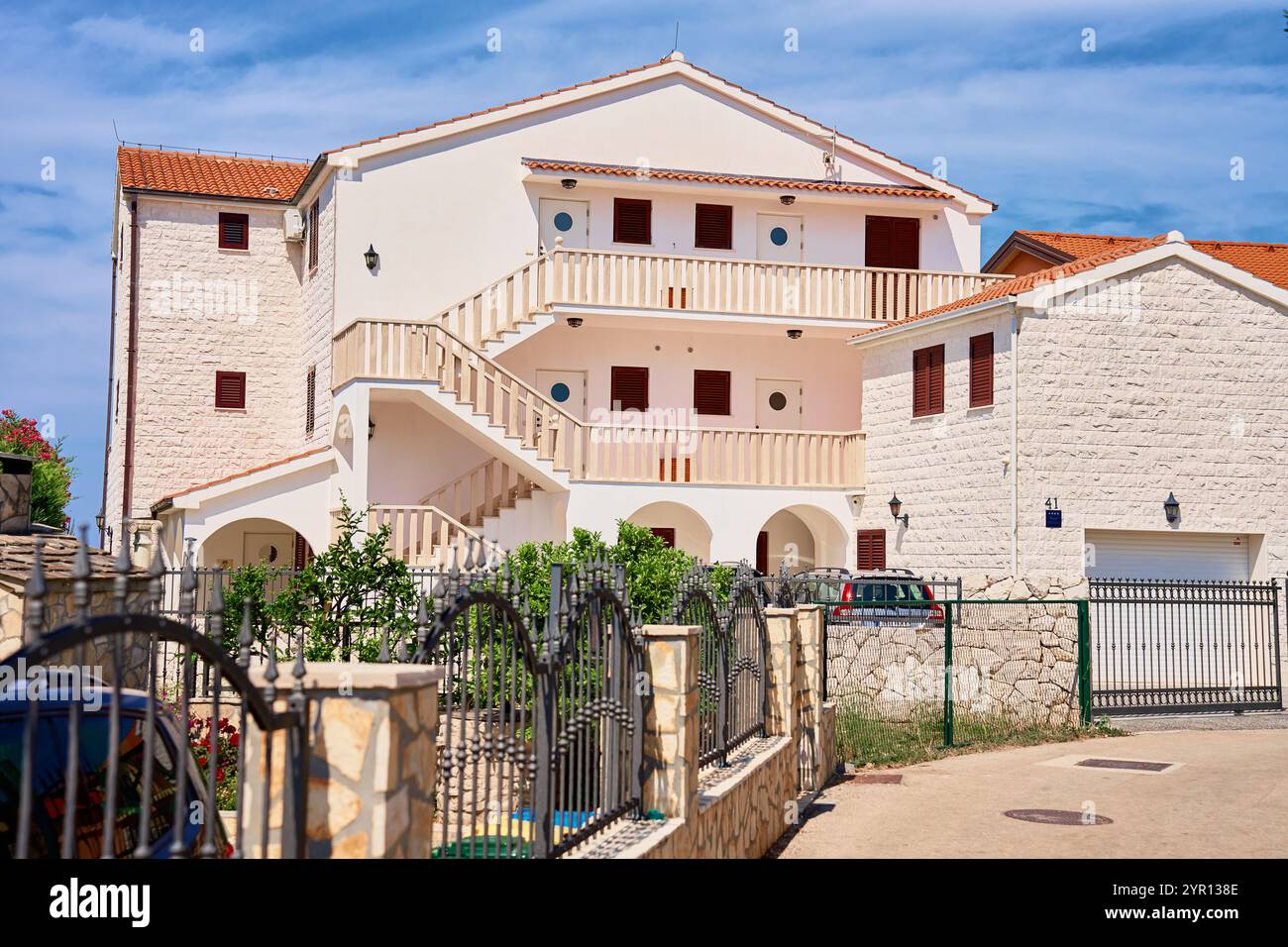 Residential building with external staircase, balconies and fenced yard ...