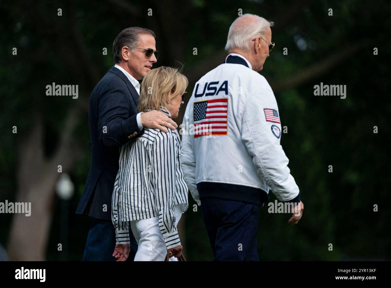 File photo - President Joe Biden, wearing a Team USA jacket, walks with ...