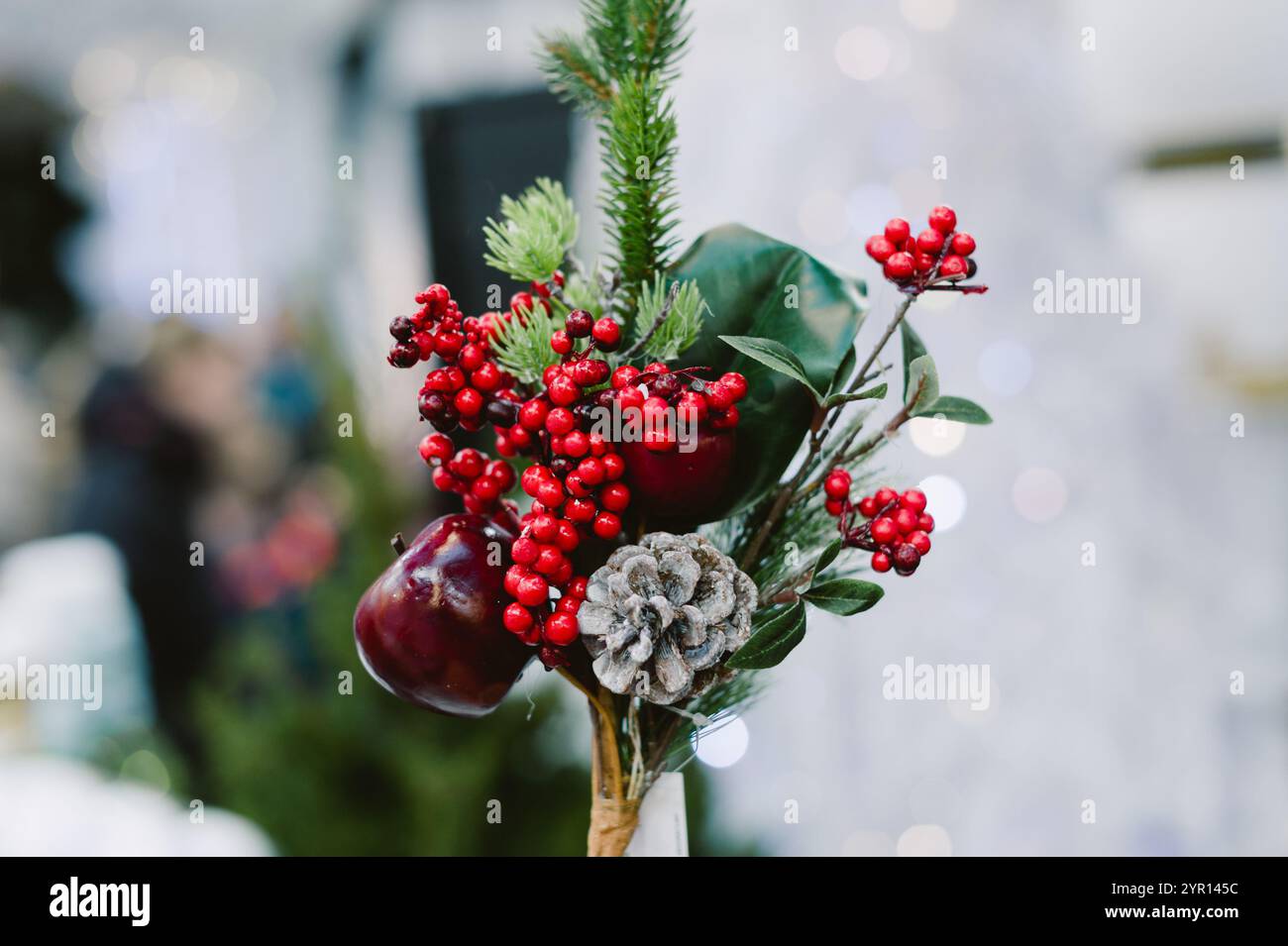 A red and green Christmas decoration with a pine cone and an apple. The ...