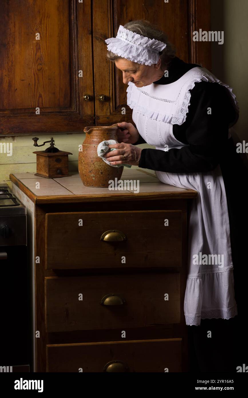 Victorian maid or servant in black dress, lace cap and white apron ...