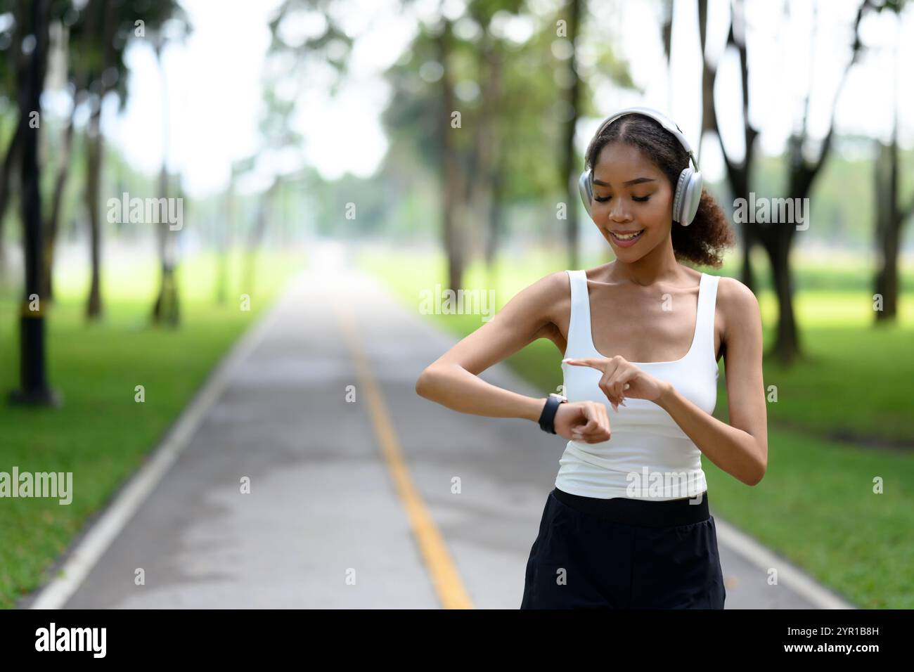 Fit young African woman monitoring her exercise progress on a ...