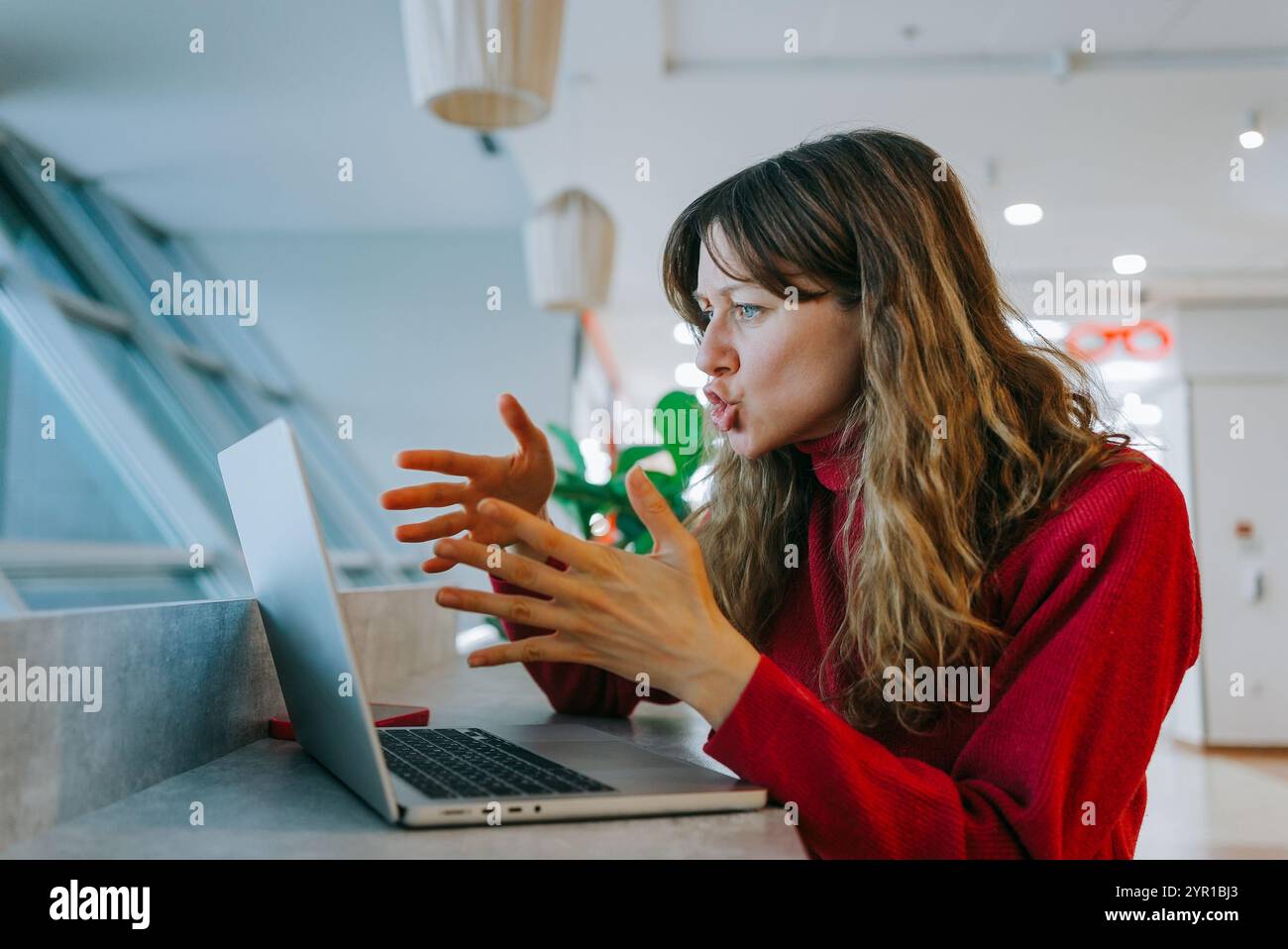 Frustrated businesswoman arguing during video call in modern office ...