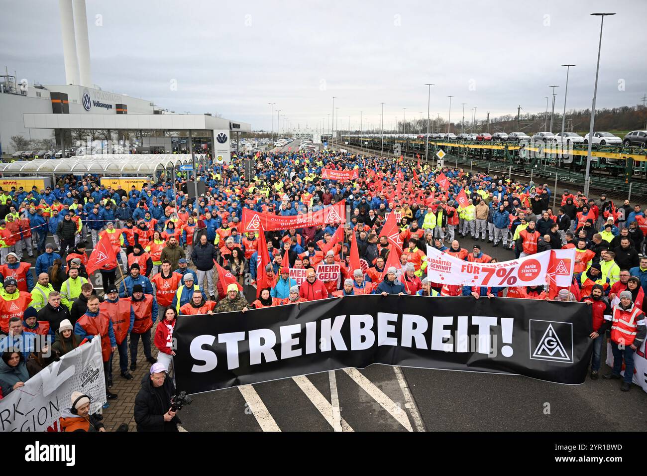 Volkswagen workers march holding a sign with writing reading in German ...