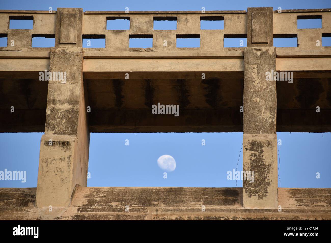 View of the moon through dam wall columns Stock Photo - Alamy