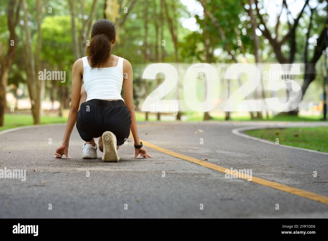 Chasing Goals in 2025. Young woman crouching in a starting position on ...