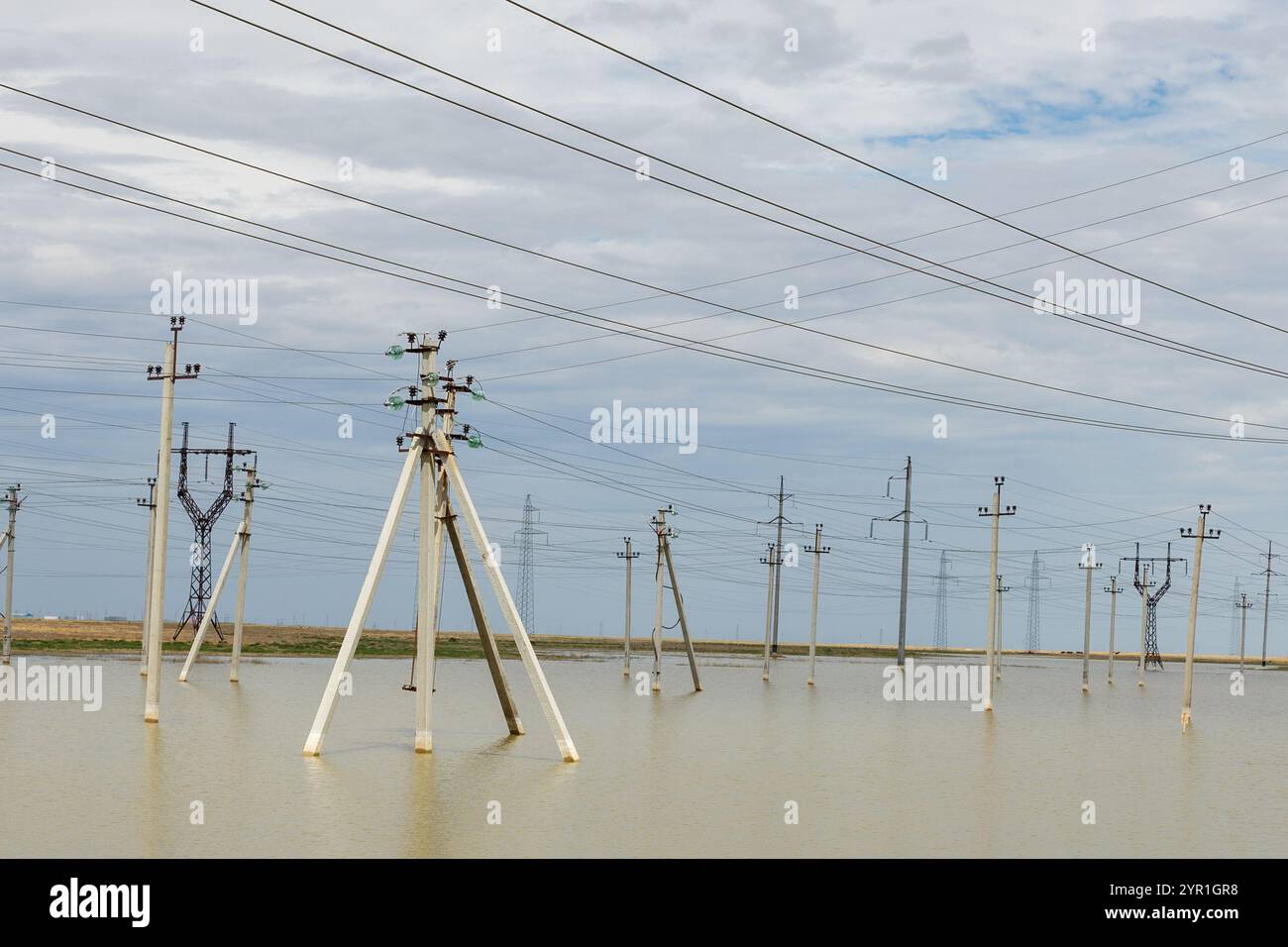 Power lines stand tall above rising waters, showcasing a rural ...