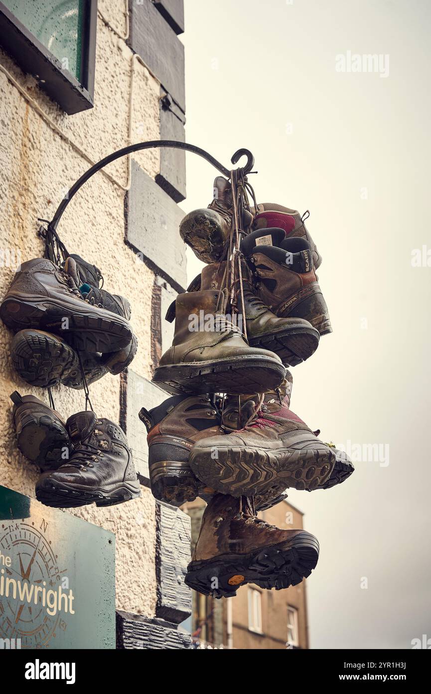 A display of old hiking boots hanging from an hock outside The ...