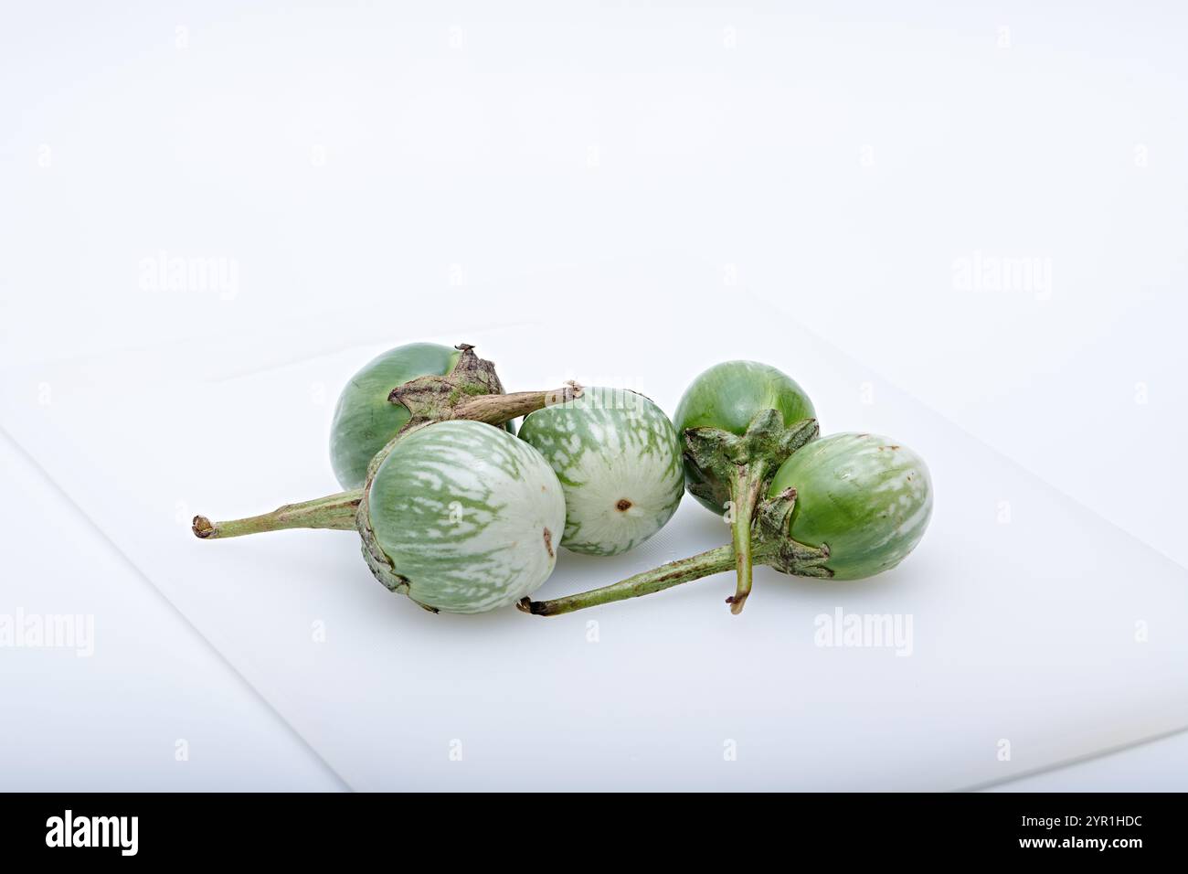 Healthy green round mini eggplant vegetable photographed with white ...
