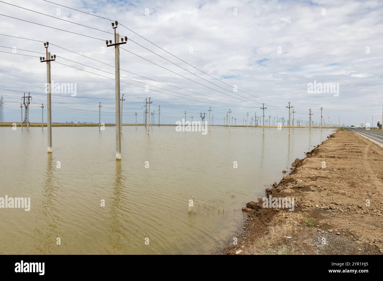 A rural area is flooded, with power lines rising above the water level ...