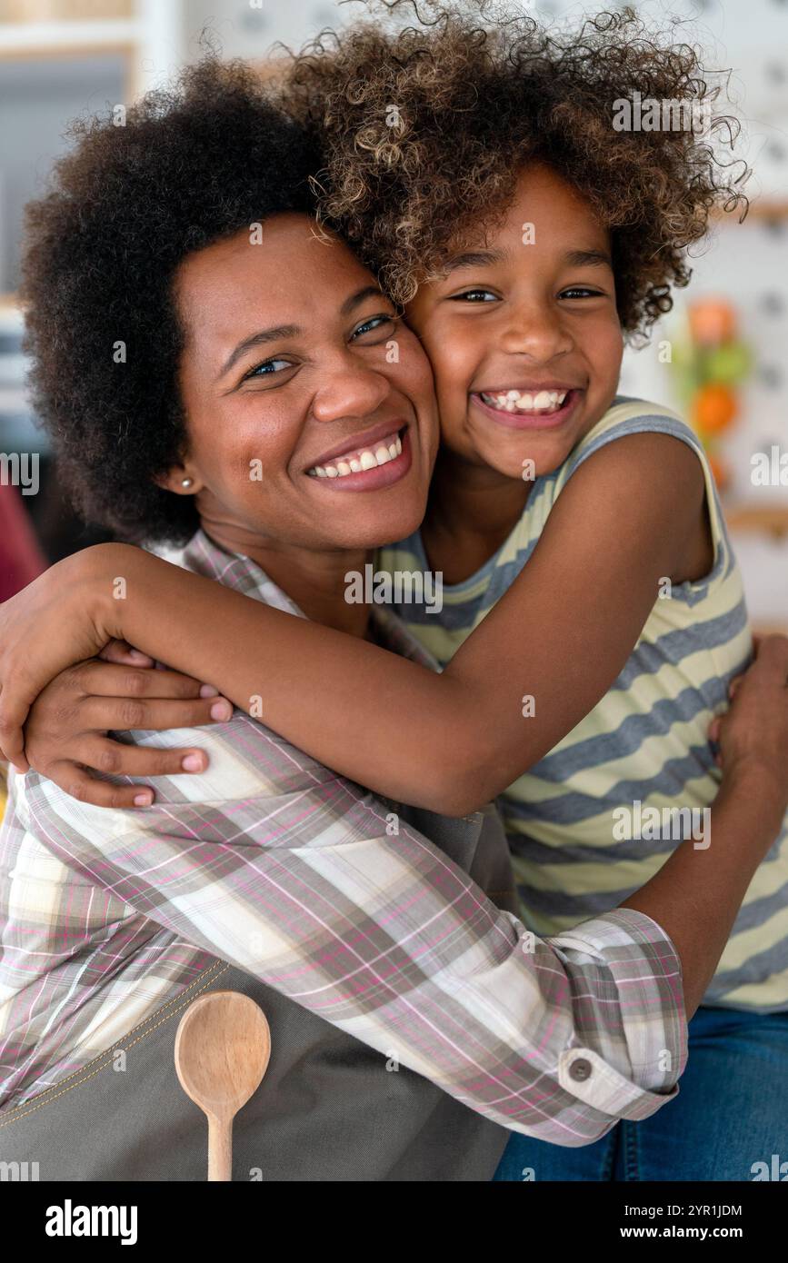 African american woman hugging her smiling teen daughter. Family love single parent child ...