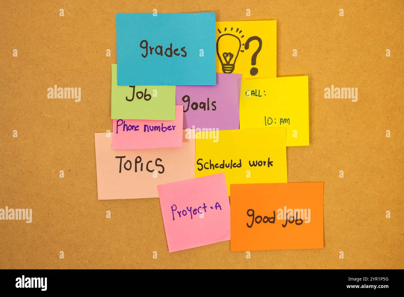 Multi colored notes on a brown board, concept of work organization and ...