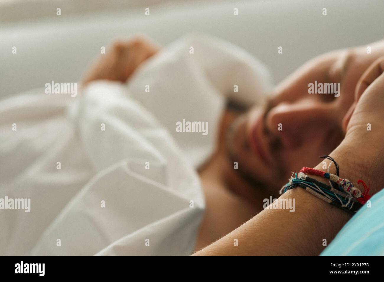 Sleeping man, close-up of hand with colored bracelets Stock Photo - Alamy