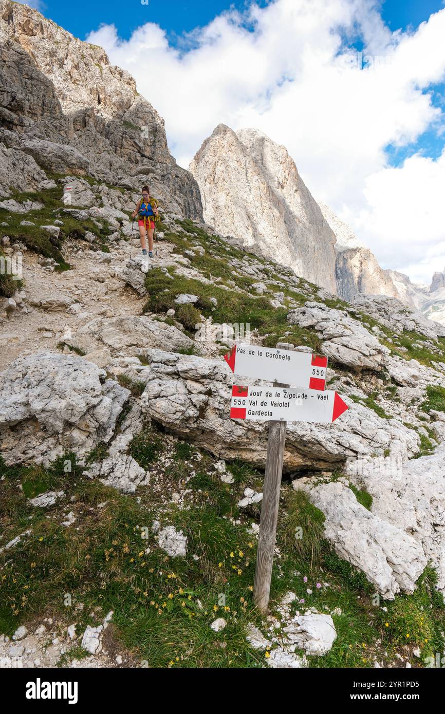 A single woman hiker walks down a rocky path in the Italian Alps Stock ...