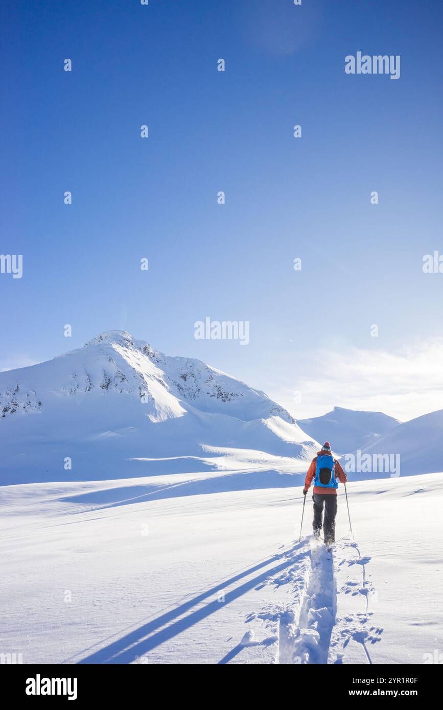 Rear view of man ski touring, breaking trail with fresh tracks Stock ...