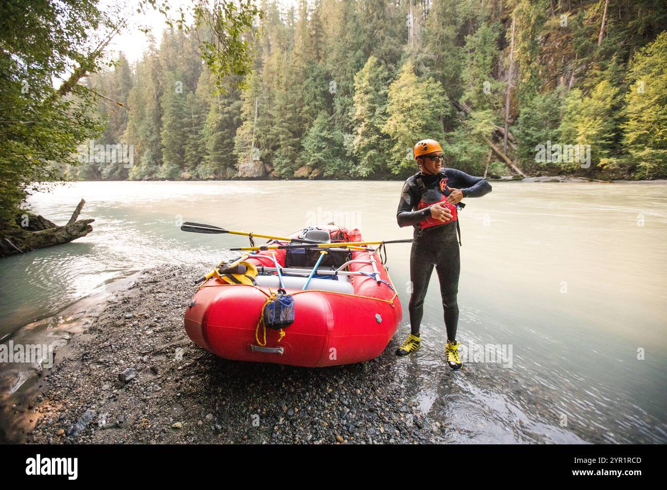 Raft guide puts on PFD before a whitewater rafting trip Stock Photo - Alamy