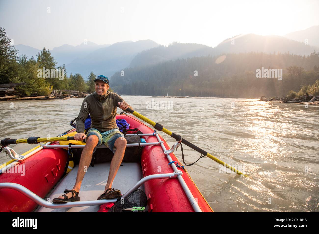Guide rowing red inflatable raft on river at sunrise Stock Photo - Alamy