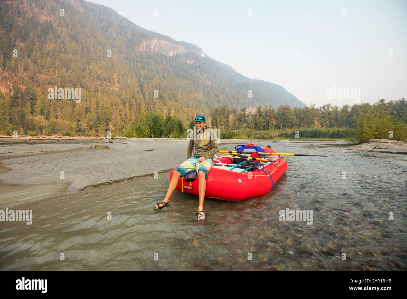Raft guide floats on the bow of his boat through a shallow channel ...