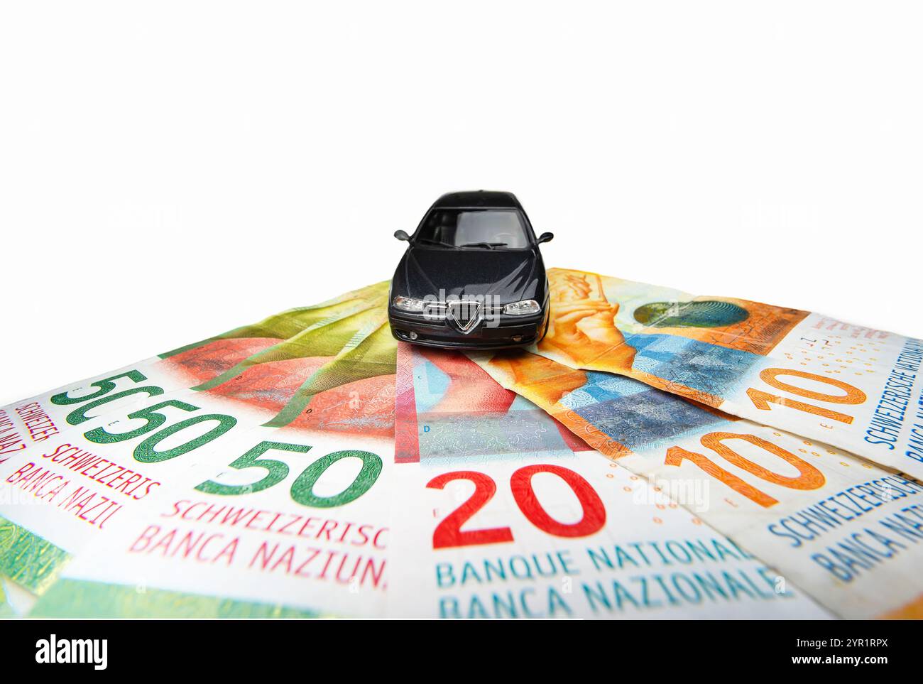 Small metal toy model car on a spread stacks of 10, 20 and 50 Swiss ...