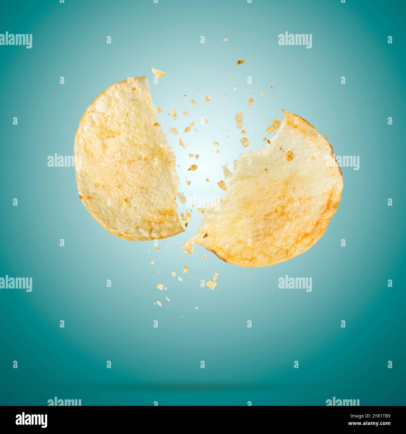 Broken potato chip with crumbs falling on blue background Stock Photo ...