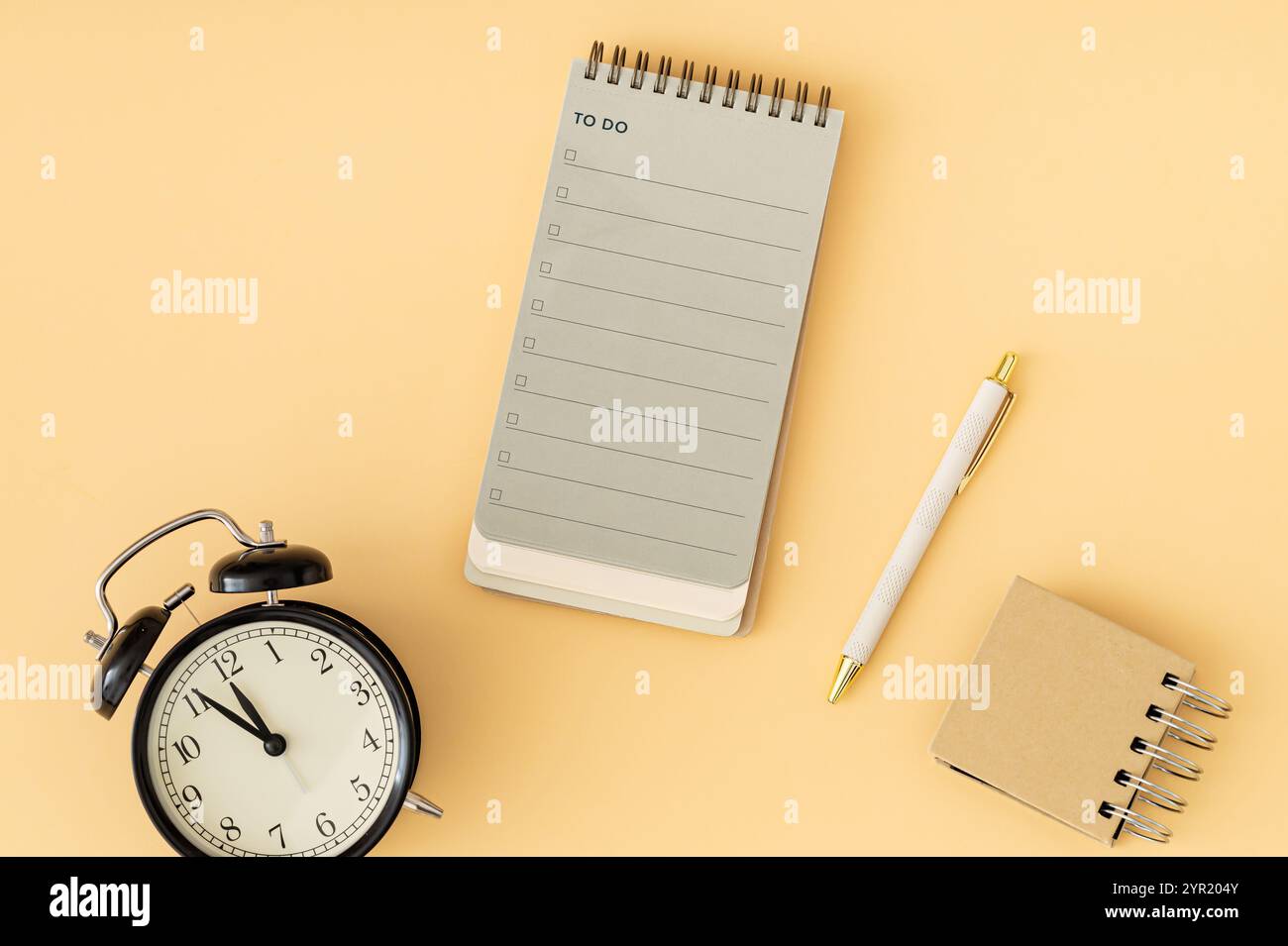 To do list in spiral notepad., retro alarm clock and white pen. Trendy ...