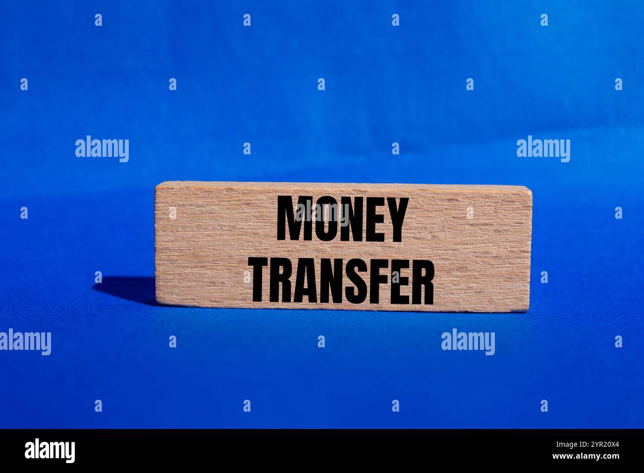 Money transfer message written on wooden block with blue background ...