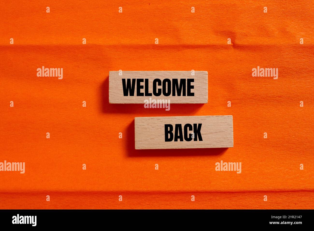 Welcome back message written on wooden blocks with orange background ...