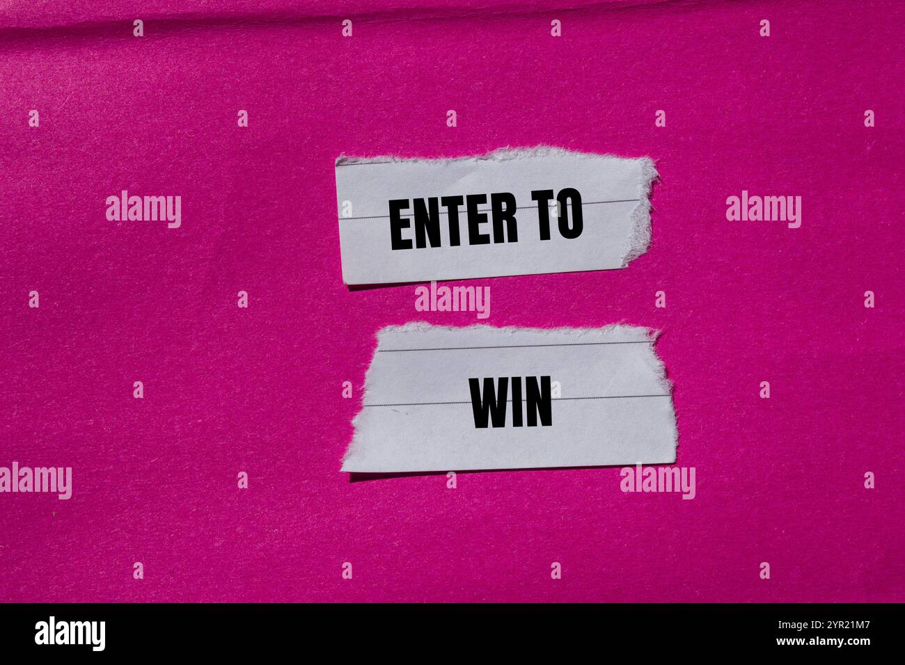 Enter to win message written on ripped torn paper pieces with pink ...