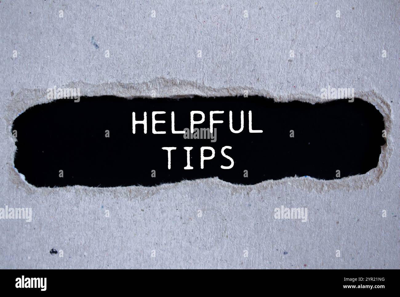 Helpful tips message written on ripped torn gray paper with black ...