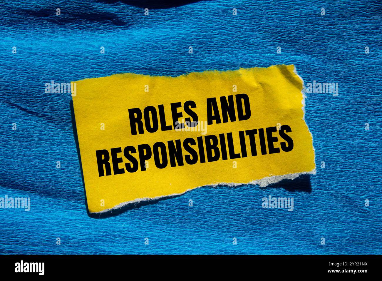 Roles and responsibilities message written on ripped torn yellow paper ...