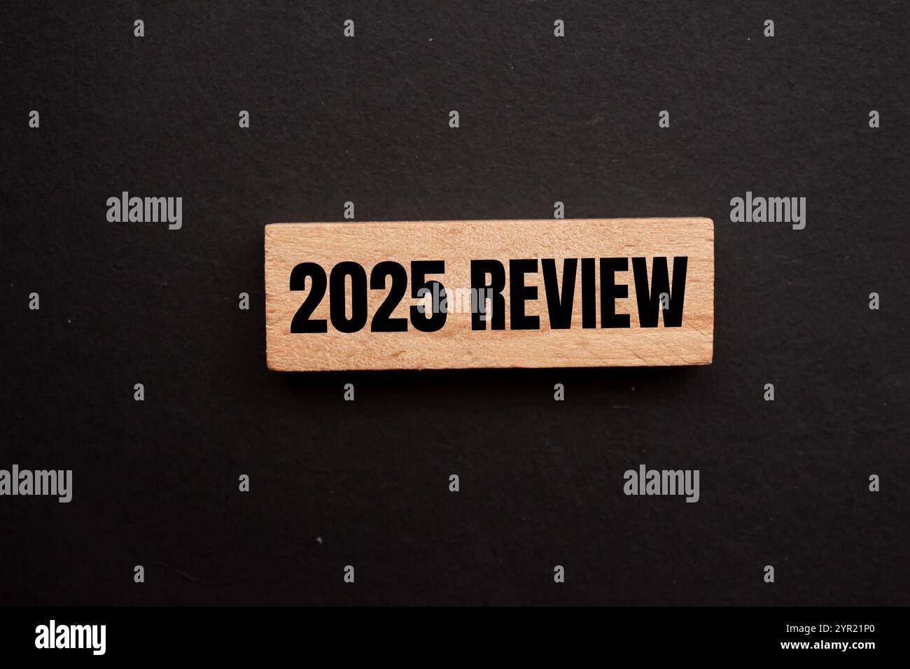 2025 review message written on wooden block with black background. Conceptual 2025 review symbol ...