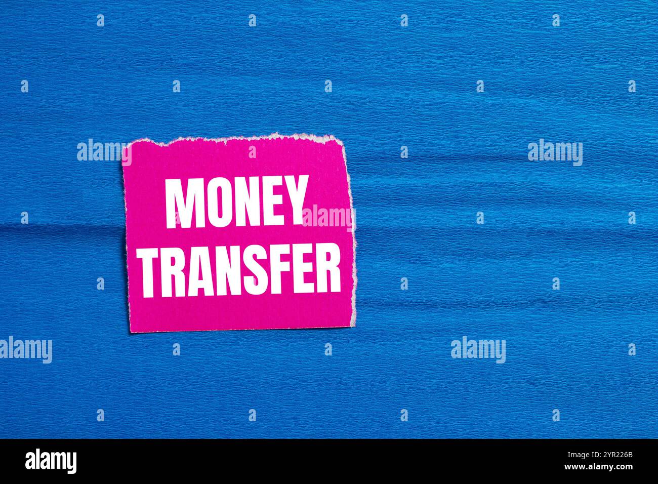 Money transfer message written on ripped pink torn paper piece with ...