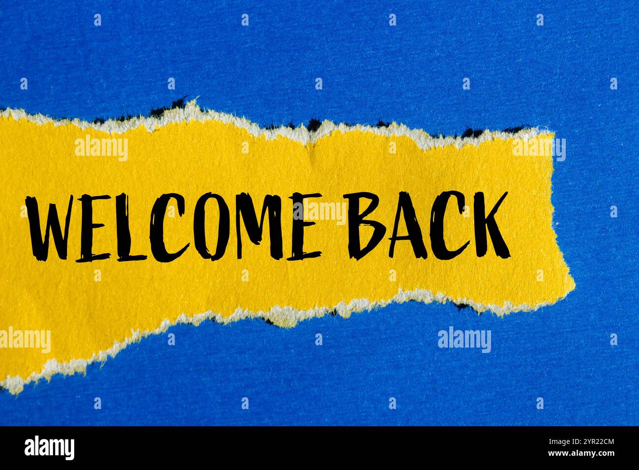Welcome back message written on ripped torn yellow paper piece with ...