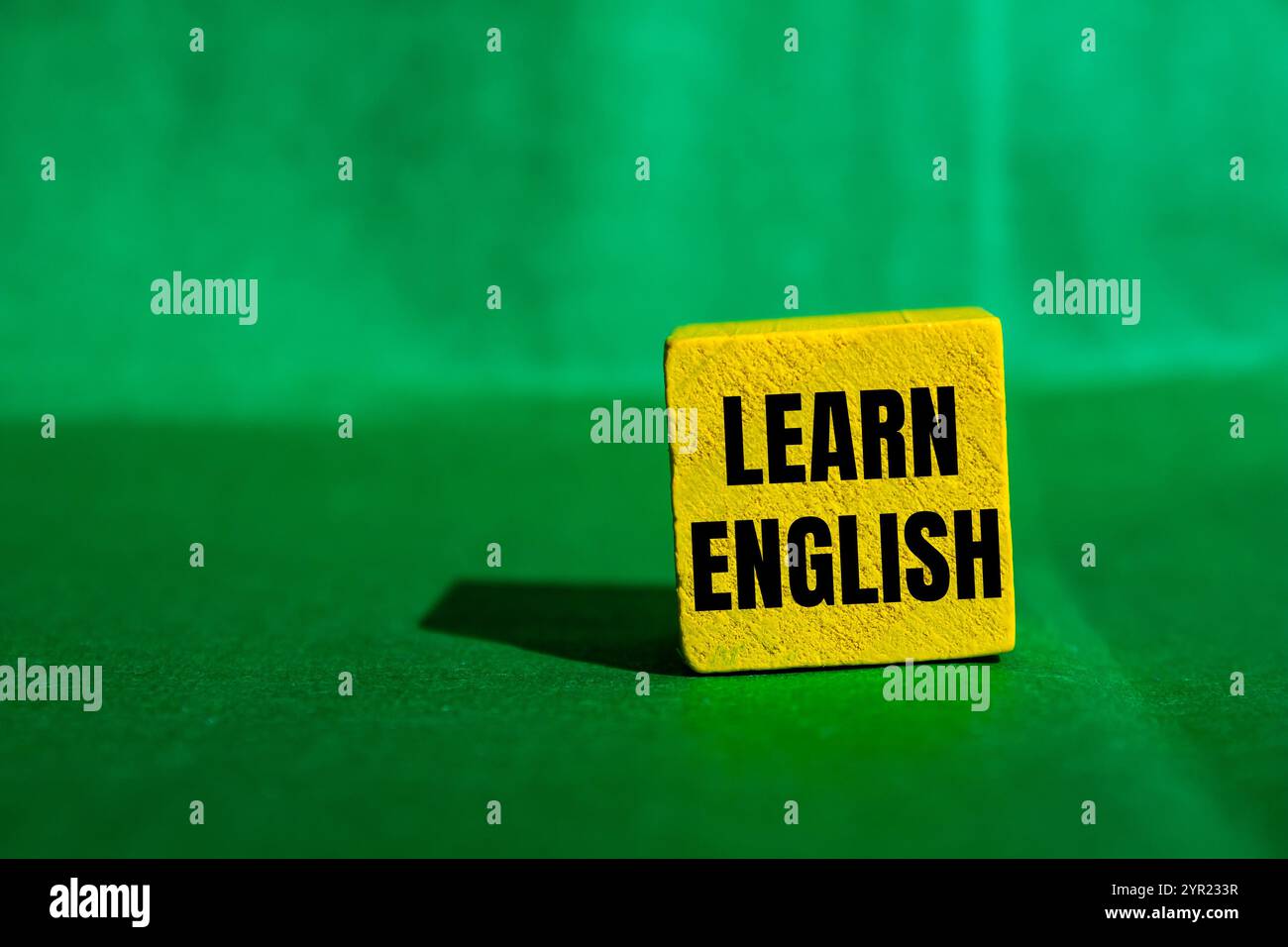 Learn english message written on yellow wooden cube with green ...