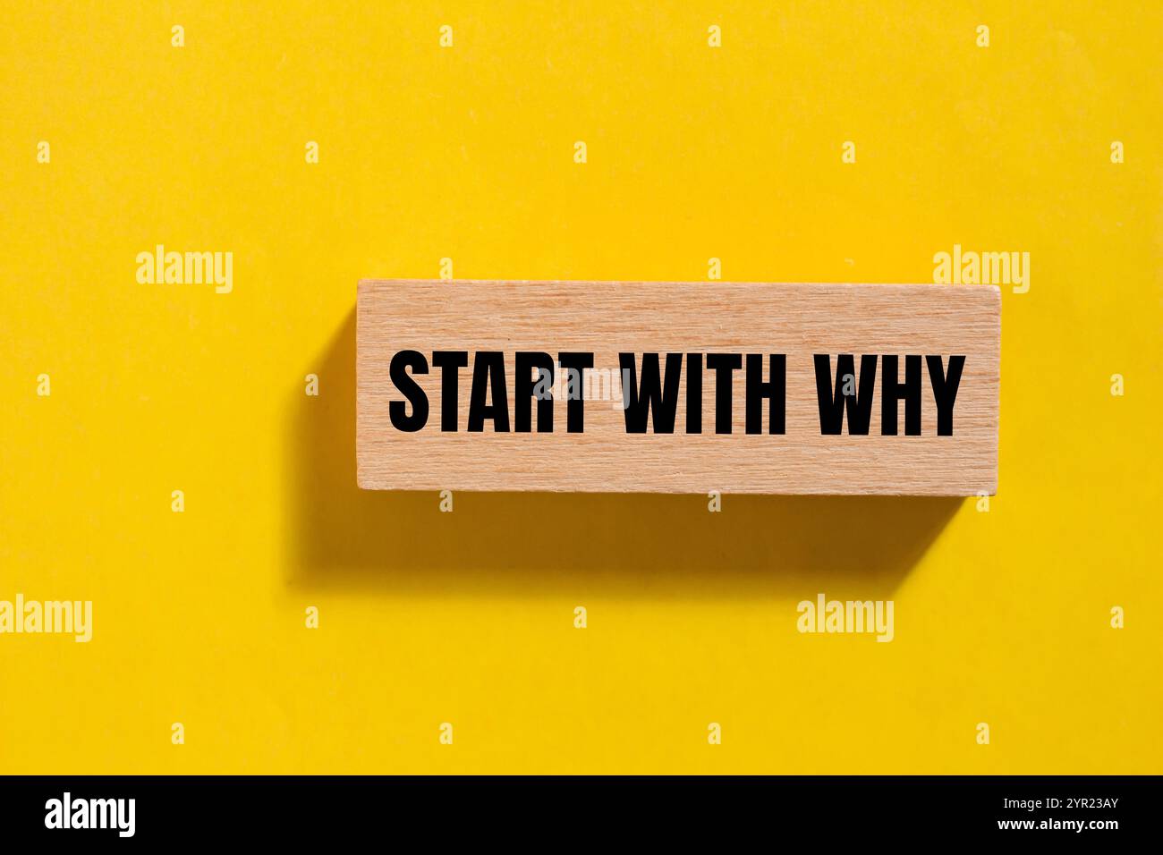 Start with why message written on wooden block with yellow background ...