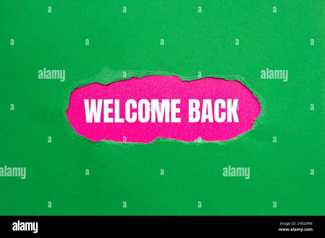 Welcome back message written on ripped torn green paper with pink background. Conceptual welcome ...