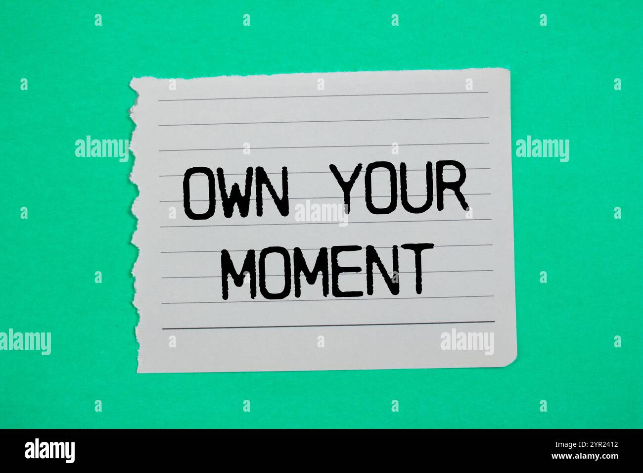 Own your moment message written on ripped torn paper piece with green ...