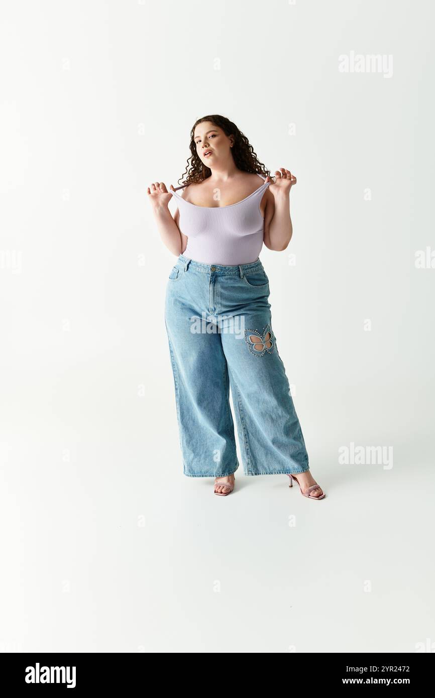 Woman in chic outfit poses with confidence against a simple backdrop ...