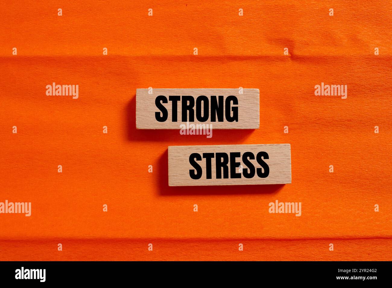 Strong stress message written on wooden blocks with orange background ...