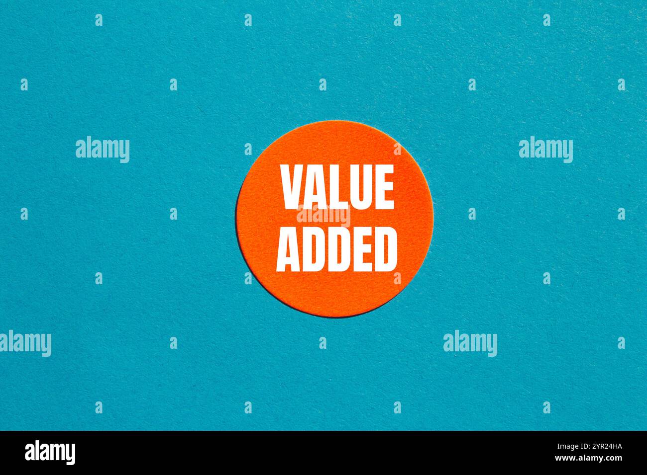 Value added message written on round orange sticker with blue ...