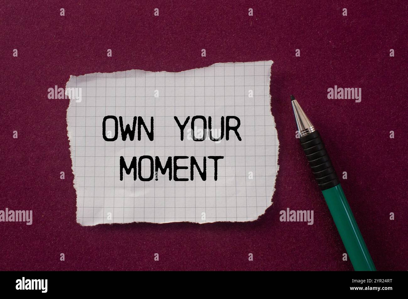 Own your moment message written on ripped torn paper piece with purple ...