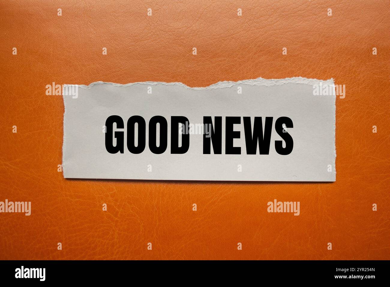 Good news message written on ripped torn paper piece with brown ...