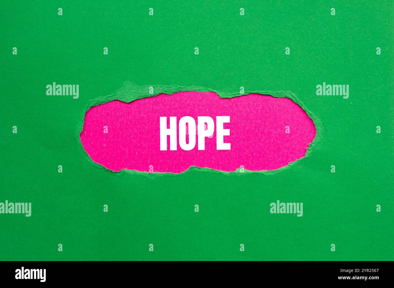 Hope message written on ripped torn green paper with pink background. Conceptual hope symbol ...