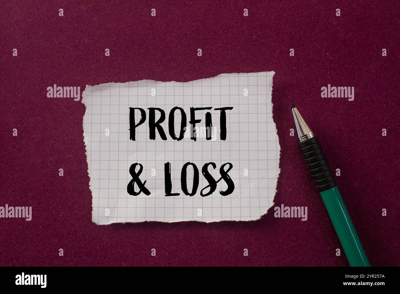 Profit and loss message written on ripped torn paper piece with purple ...